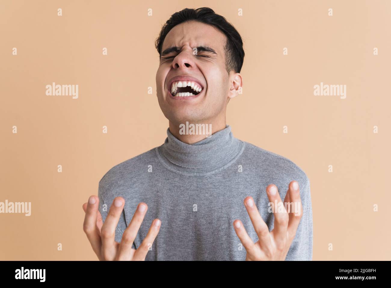 Young middle eastern man gesturing while screaming at camera isolated ...