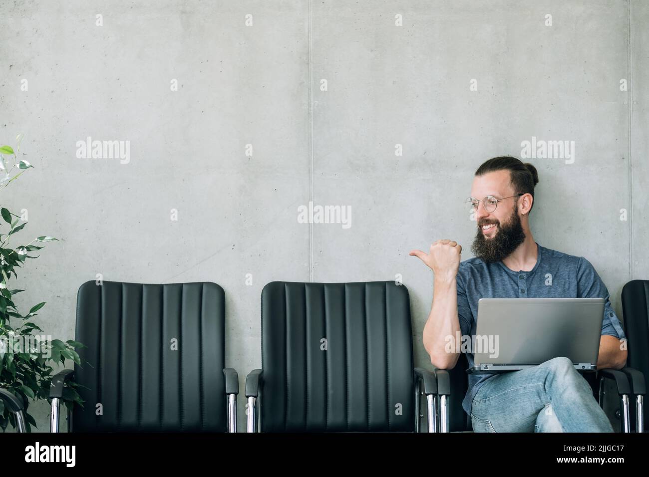 smiling man point left empty chair job interview Stock Photo - Alamy