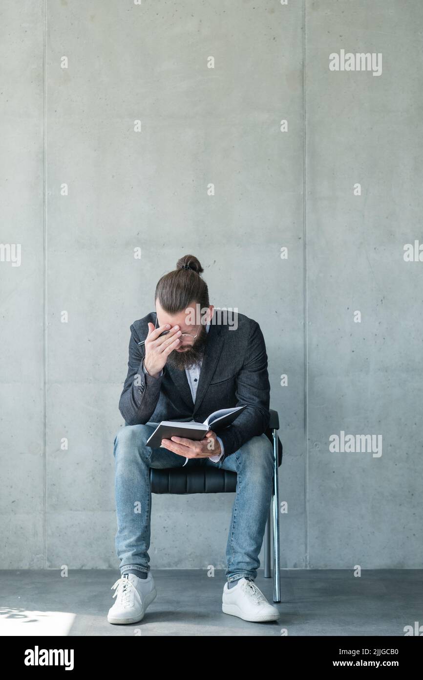 business man concentrated reading notepad fatigue Stock Photo - Alamy