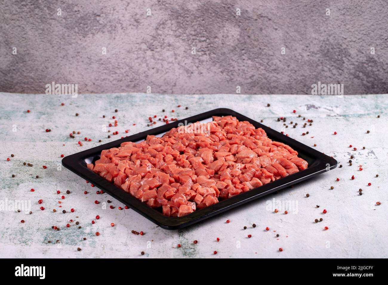 Cubed meat. Chopped red meat on stone background. Butcher products ...
