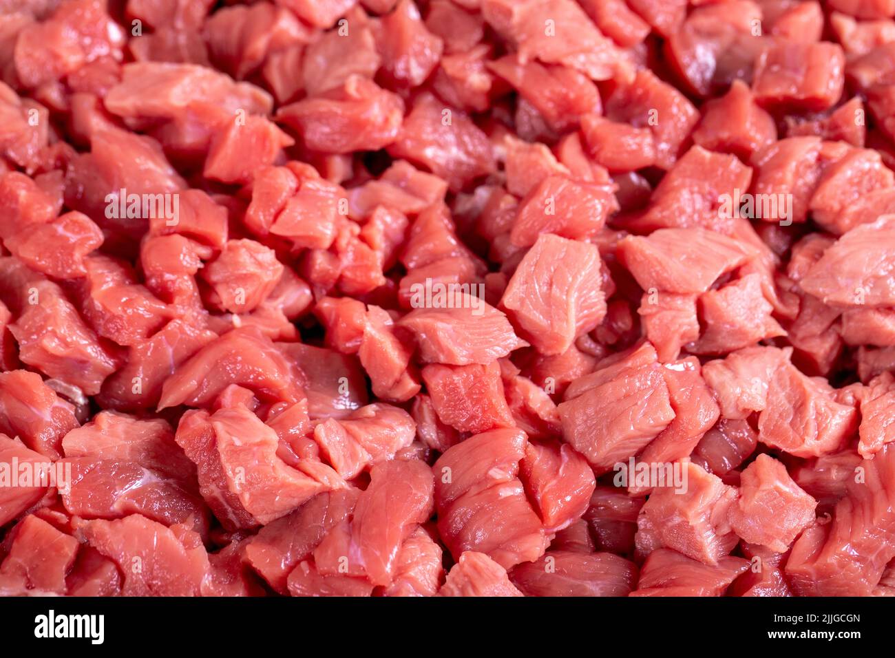 Cubed meat. Chopped red meat on stone background. Butcher products ...