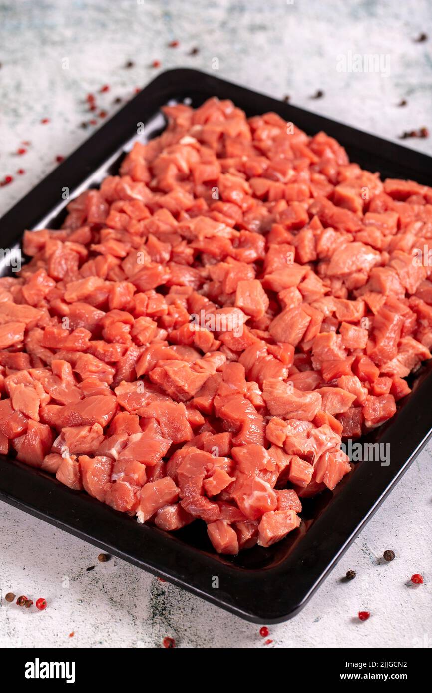 Cubed meat. Chopped red meat on stone background. Butcher products ...
