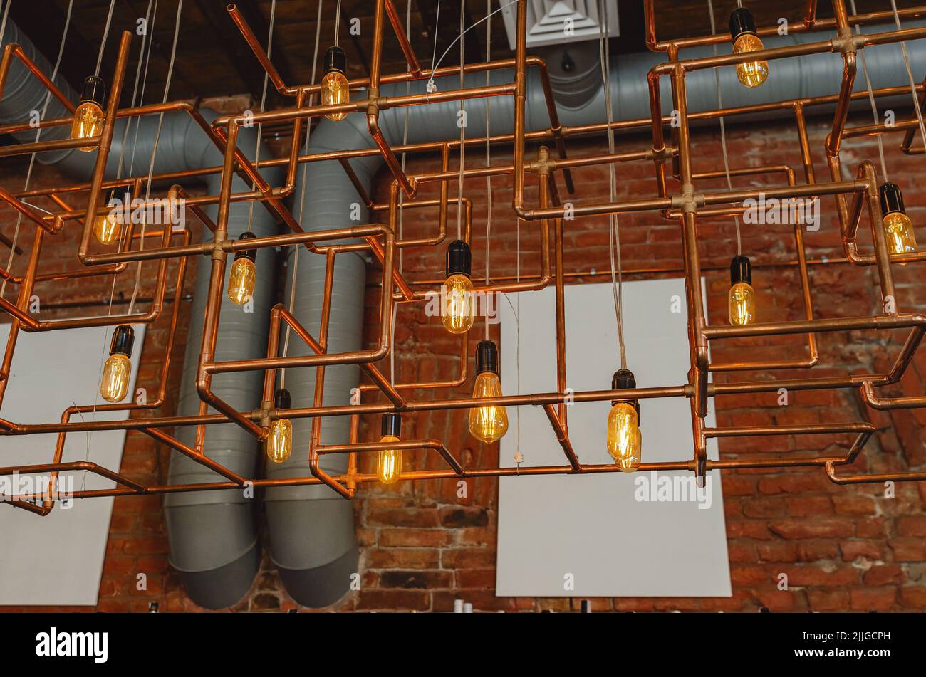 Modern loft lamp made of copper pipes in cafe Stock Photo - Alamy