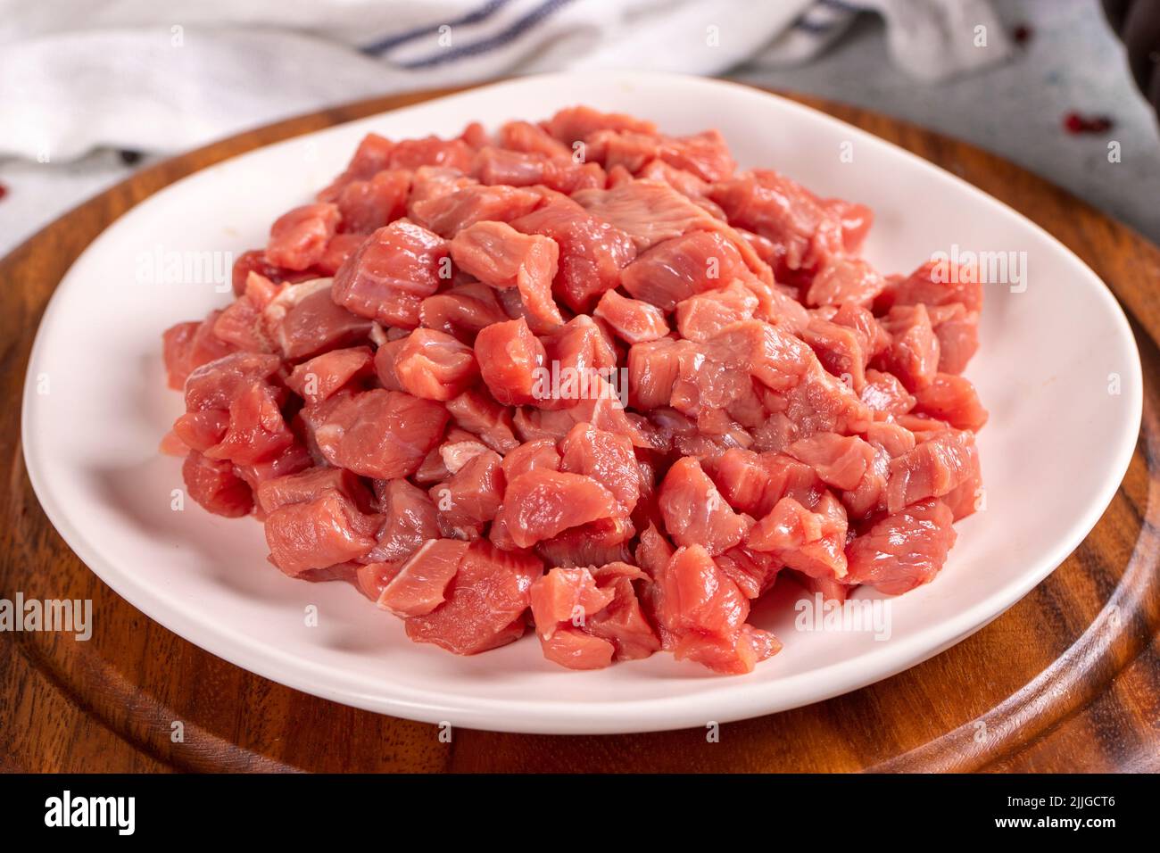 Cubed meat. Red meat in a chopped plate on a stone floor. Butcher ...