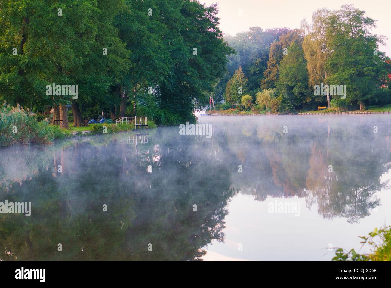 A sunrise at dawn, with fog on the river and warm light atmosphere ...