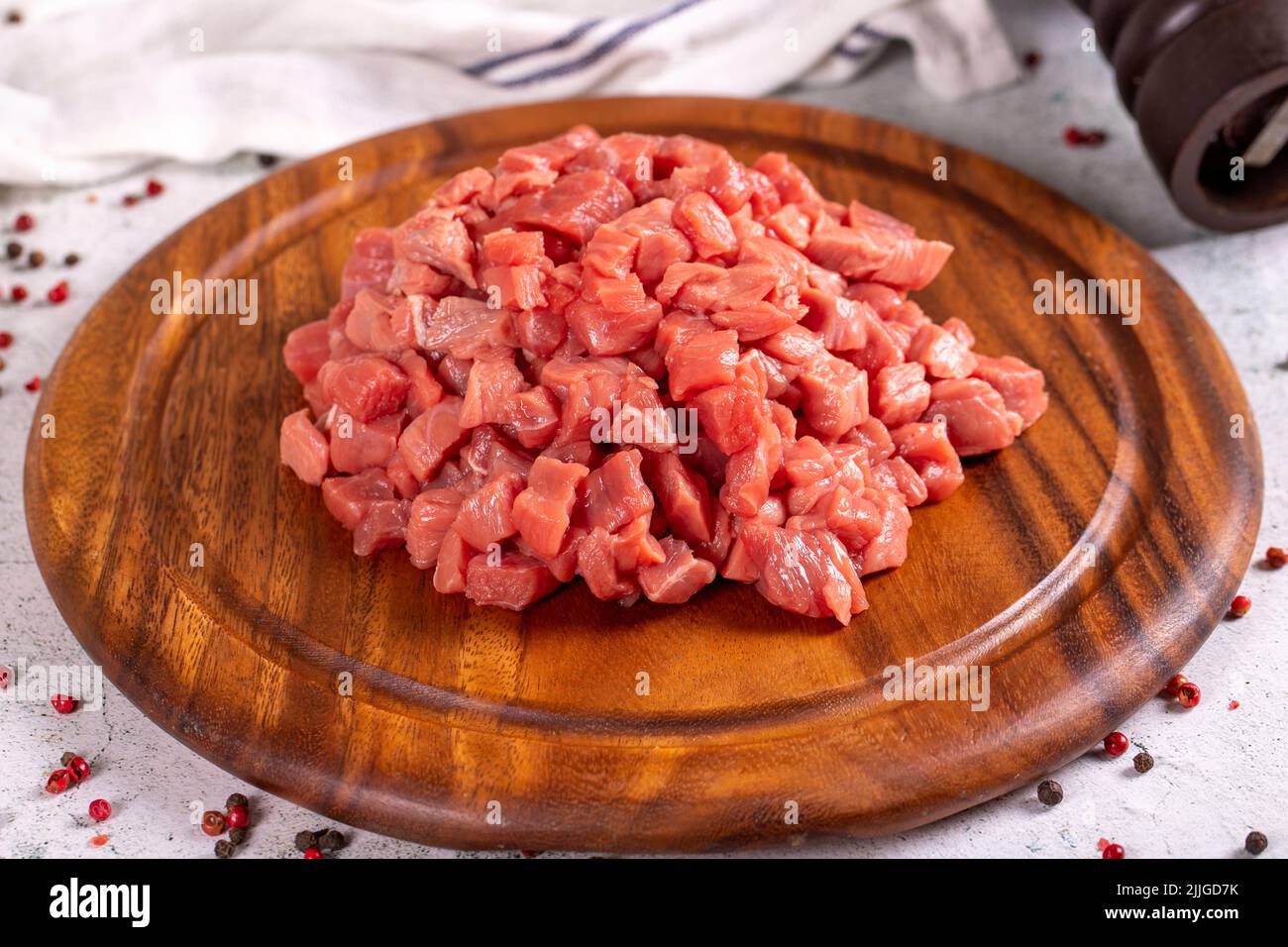 Cubed meat. Chopped red meat in a wooden serving dish on a stone ...