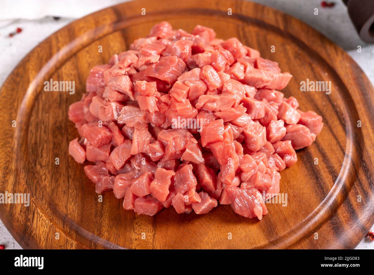 Cubed meat. Chopped red meat in a wooden serving dish on a stone ...
