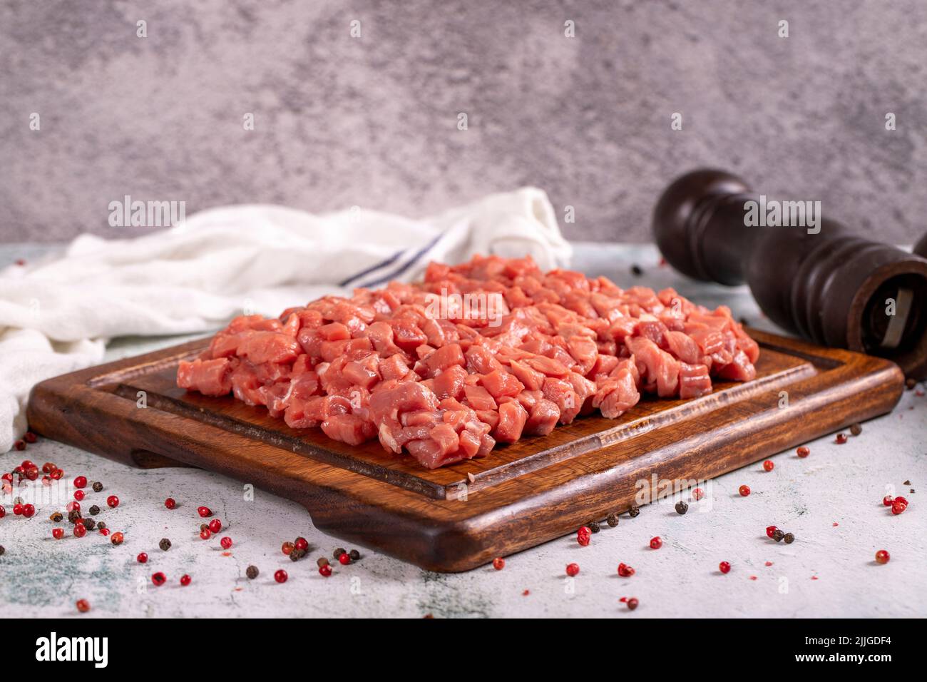 Cubed meat. Chopped red meat in a wooden serving dish on a stone ...