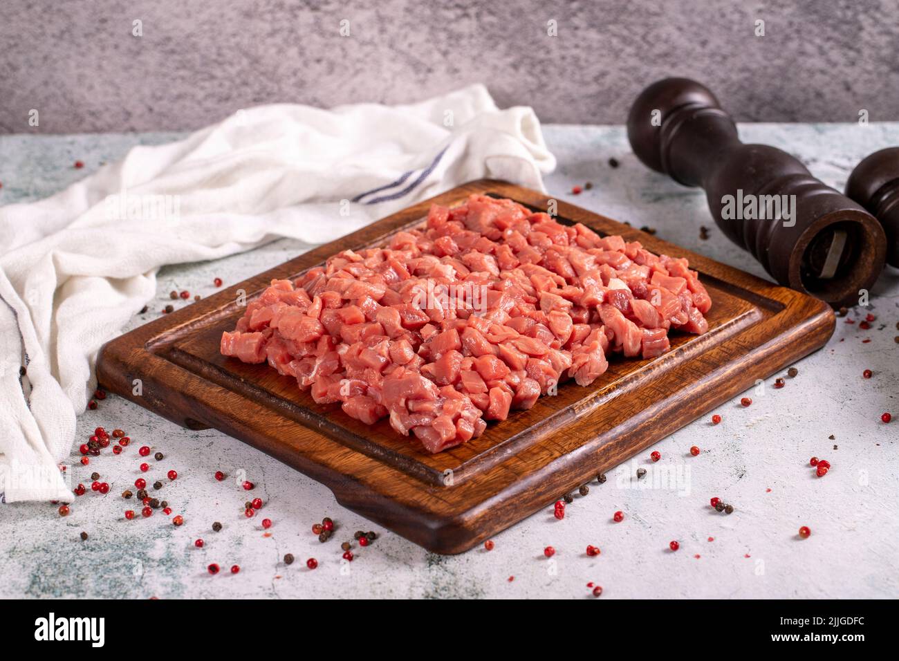 Cubed meat. Chopped red meat in a wooden serving dish on a stone ...