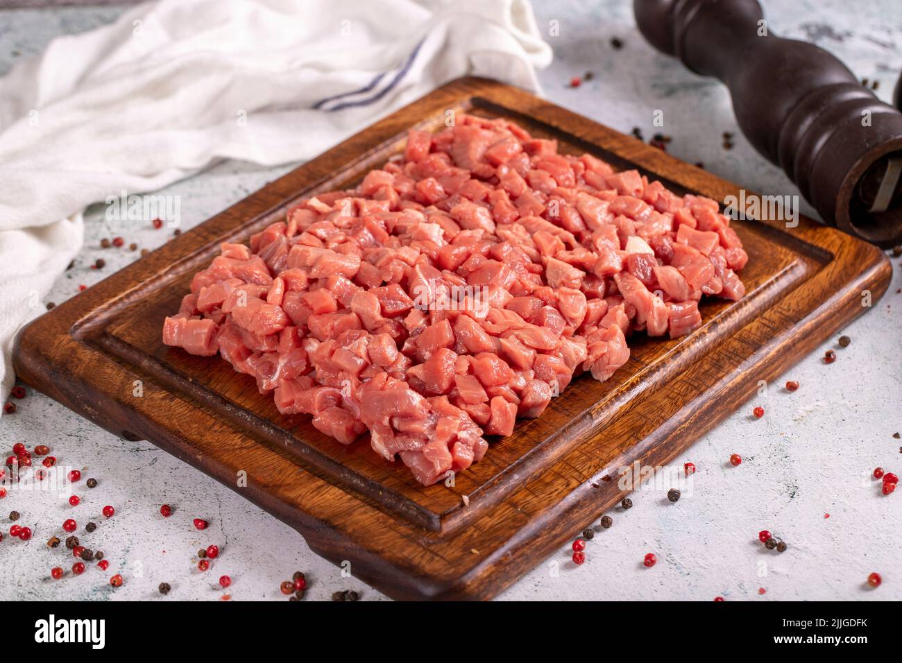 Cubed meat. Chopped red meat in a wooden serving dish on a stone ...