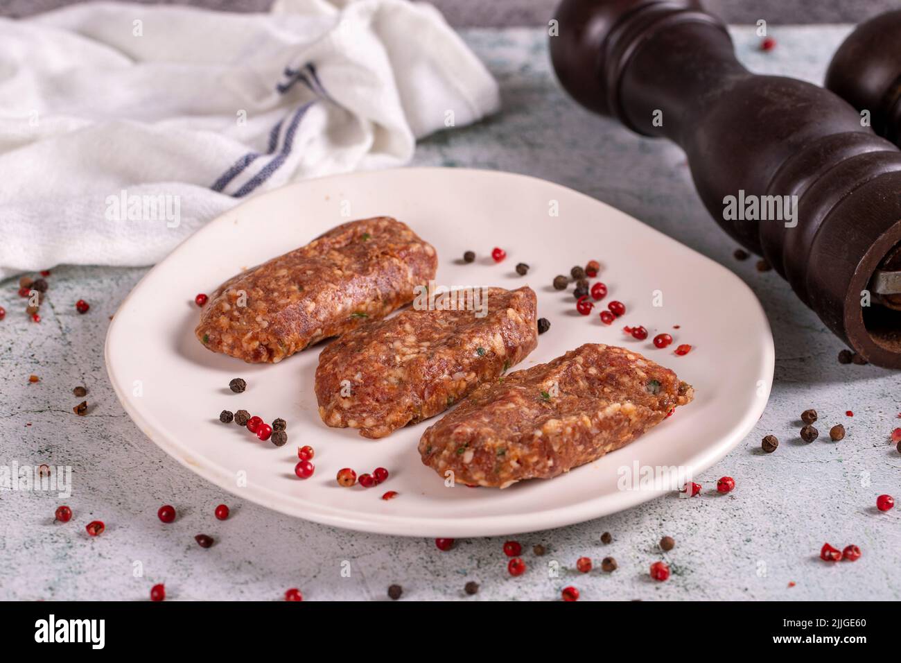 Uncooked spicy grilled meatballs. Meatballs in a plate on a stone ...