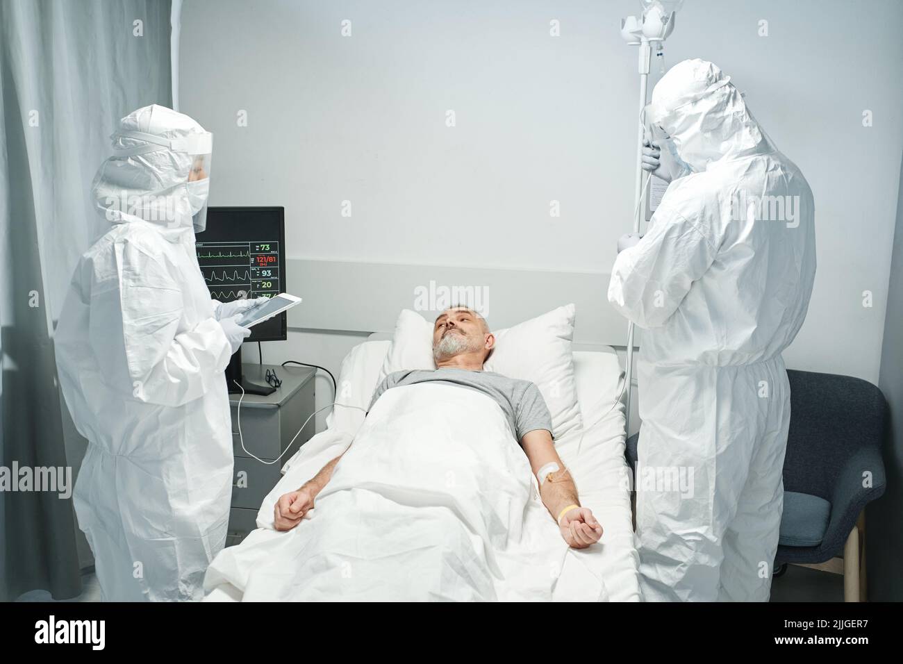 Two Medical Specialists Wearing Personal Protection Equipment Working