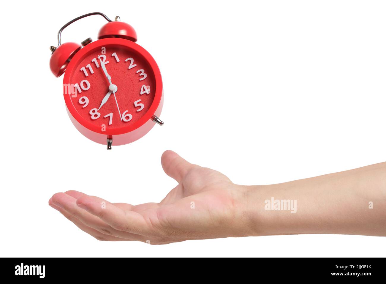 Ringing and levitating red alarm clock above hand on white background ...