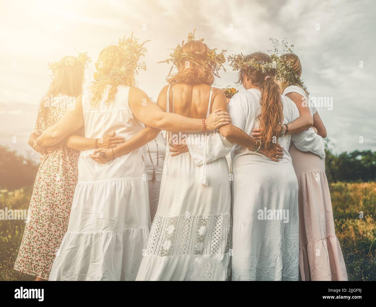 Women in flower wreath on sunny meadow, Floral crown, symbol of summer ...