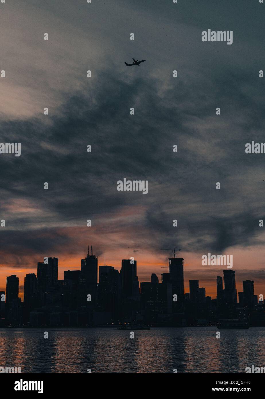 A vertical shot of an airplane in flight above the skyline during ...