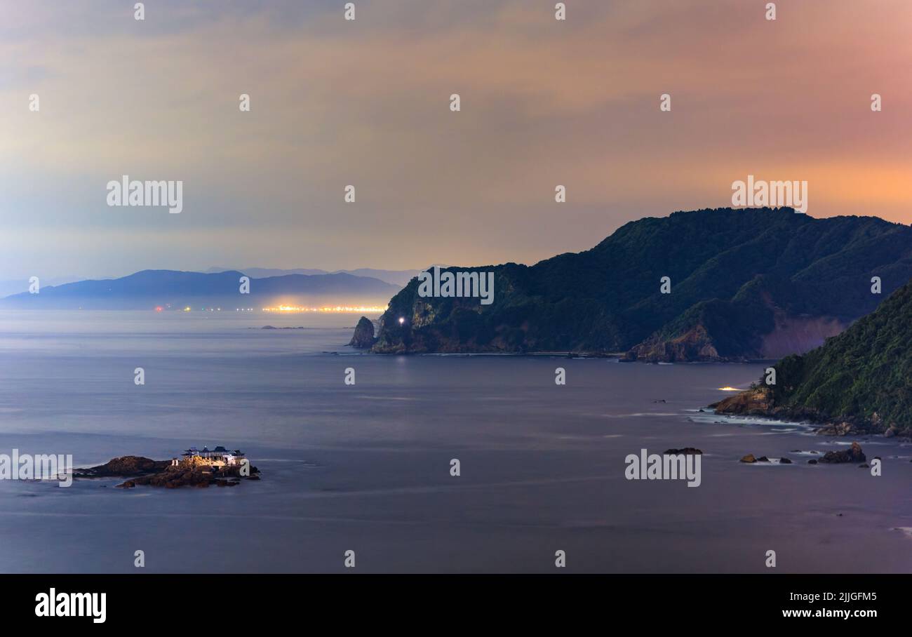 Lights on small rocky island off rugged Sea of Japan coast at night ...