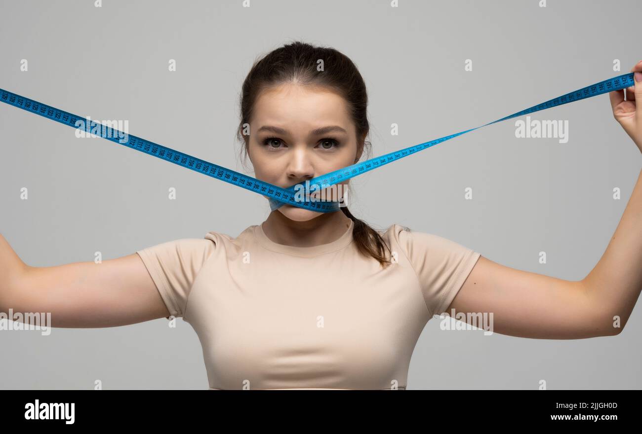 Healthy lifestyle and diet concept. Confused young brunette woman in a ...