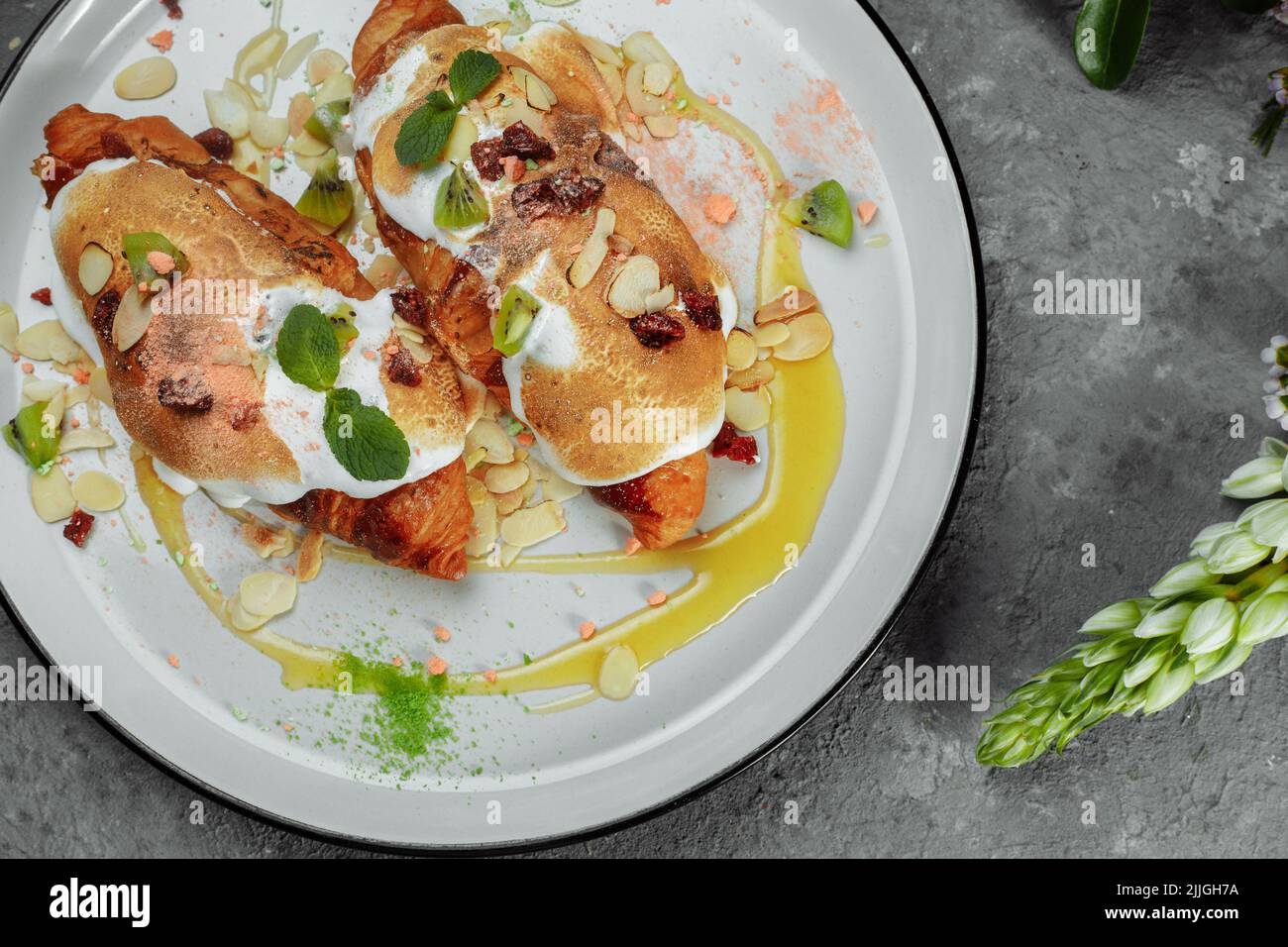 croissant with sweet cream and almonds on a plate. Delicious and ...