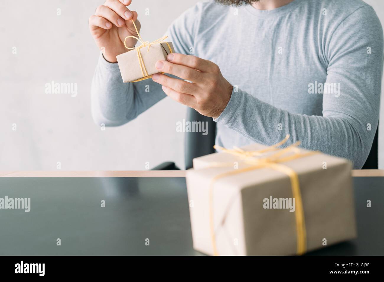 gift shop delivery service man untying present box Stock Photo - Alamy