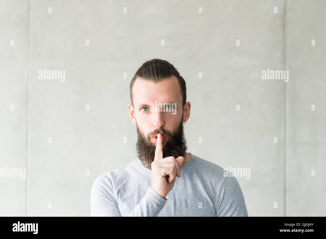 keep silence guy warning gray wall background Stock Photo - Alamy