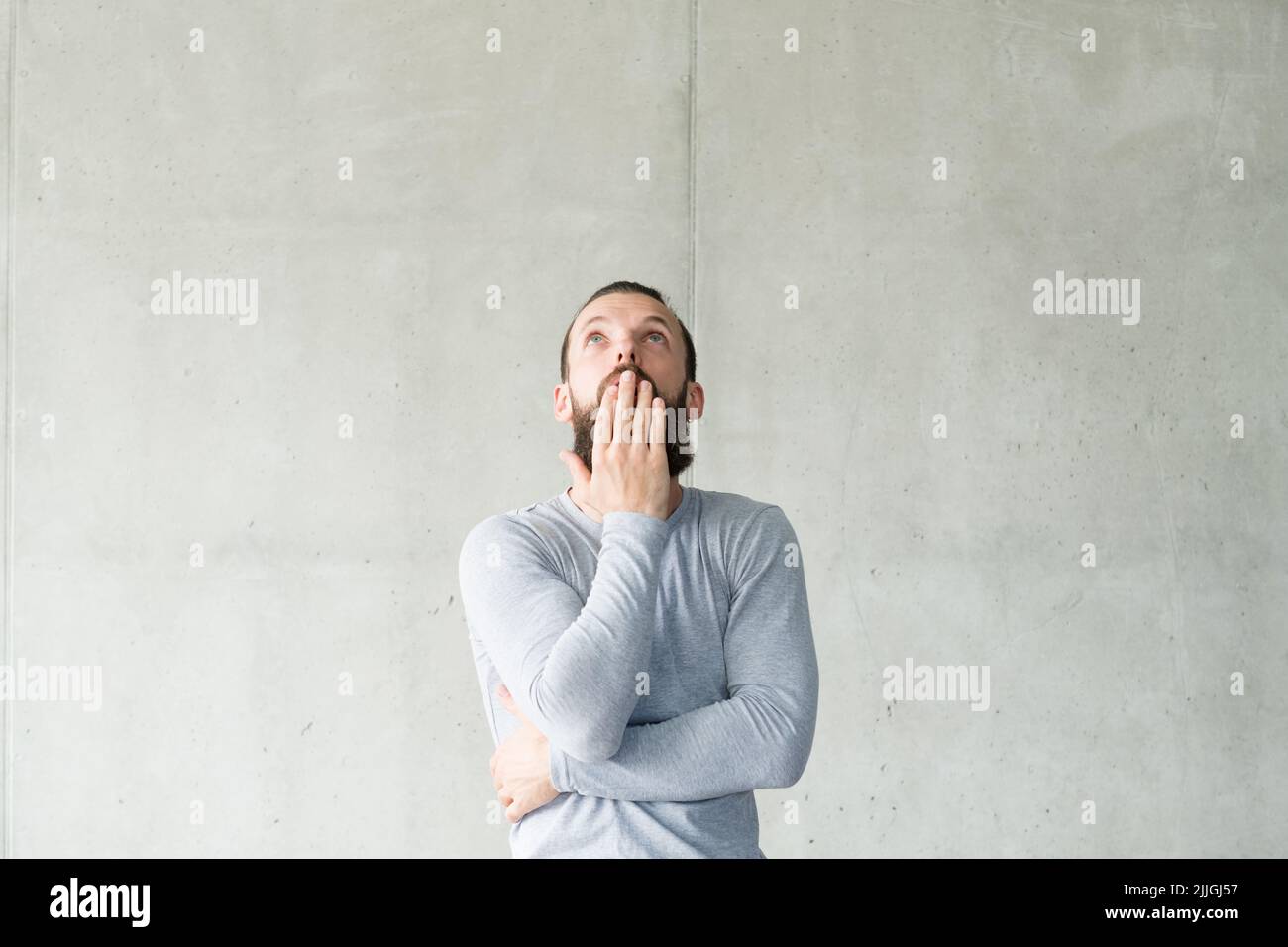 thoughtful hipster guy gray wall background Stock Photo - Alamy