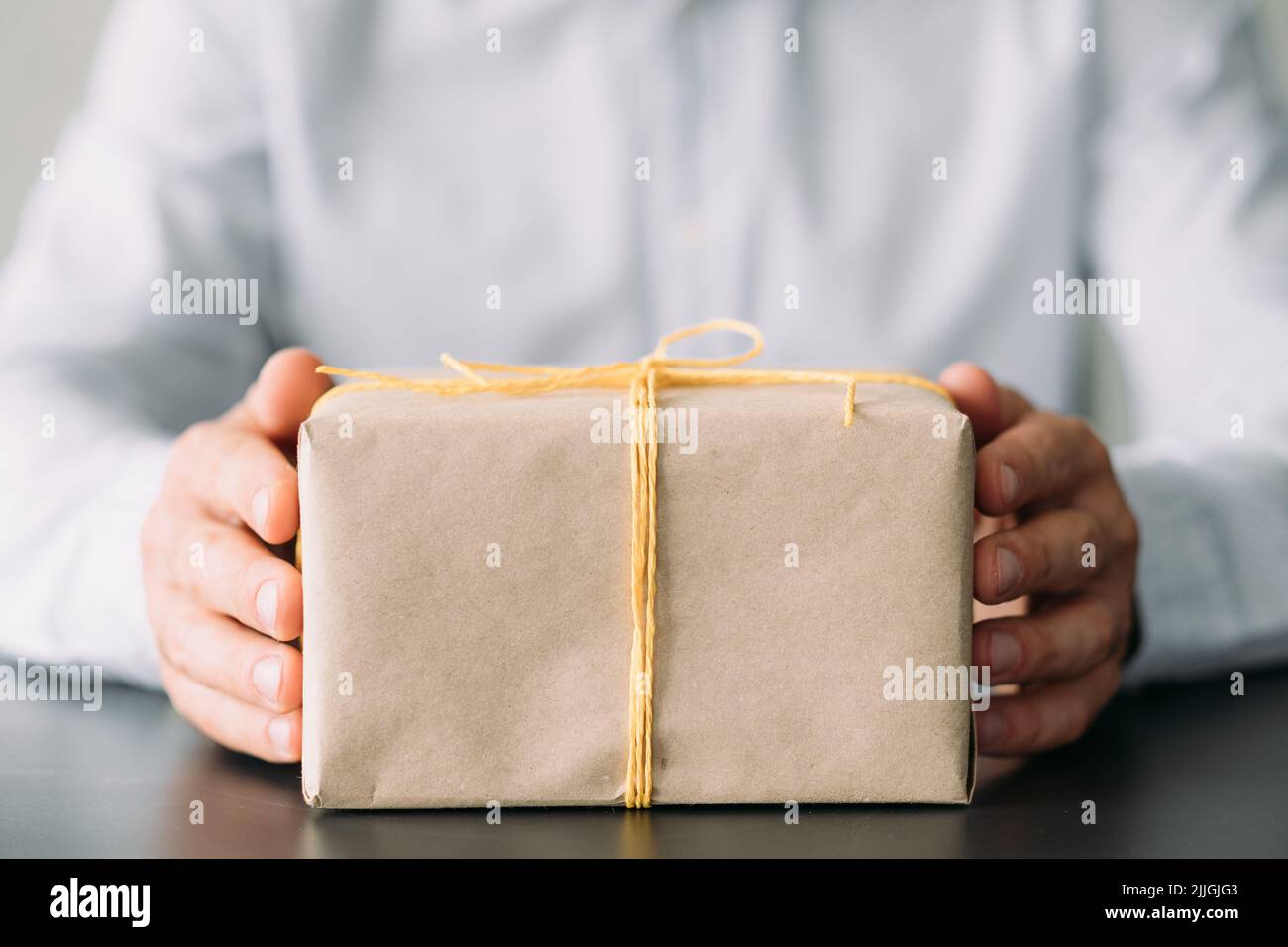 goods delivery service beige gift box man hands Stock Photo - Alamy