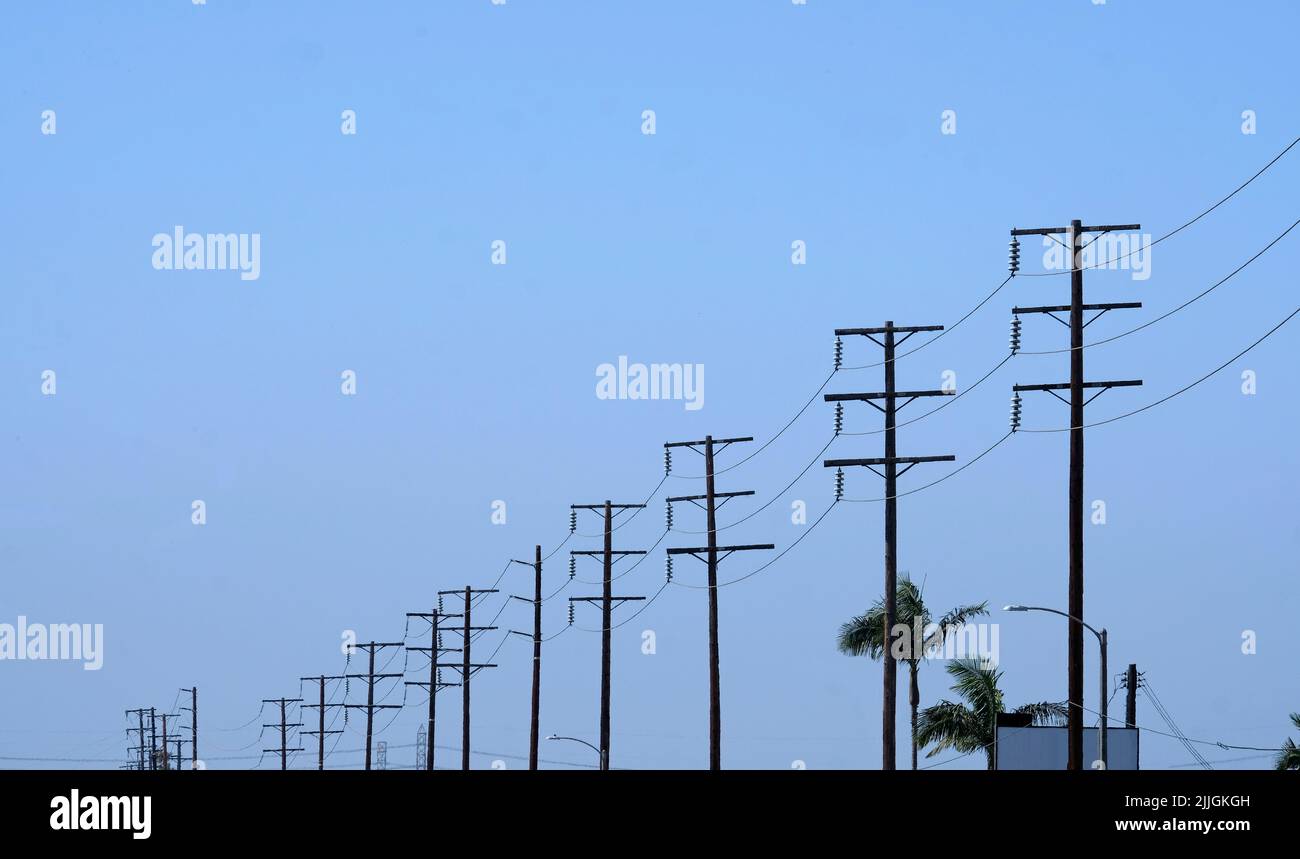 Row of power poles against a blue sky during a road trip Stock Photo ...