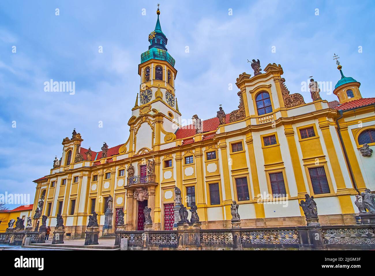 The richly decorated facade of Loreta Monastery with golden clock atop ...