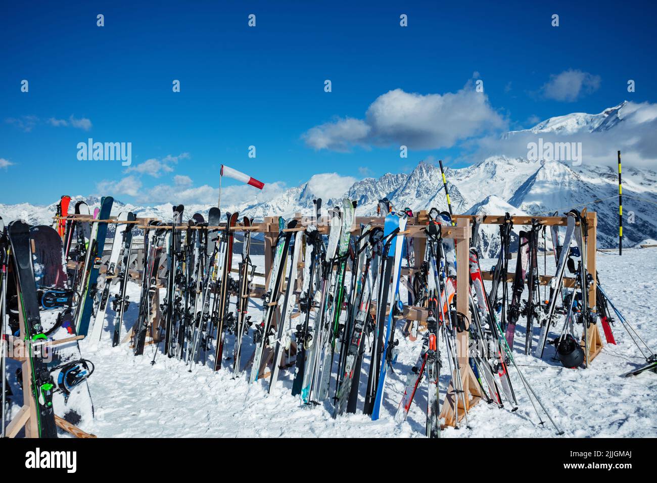Many snowboards skis stand on alpine resort over mountains Stock Photo ...