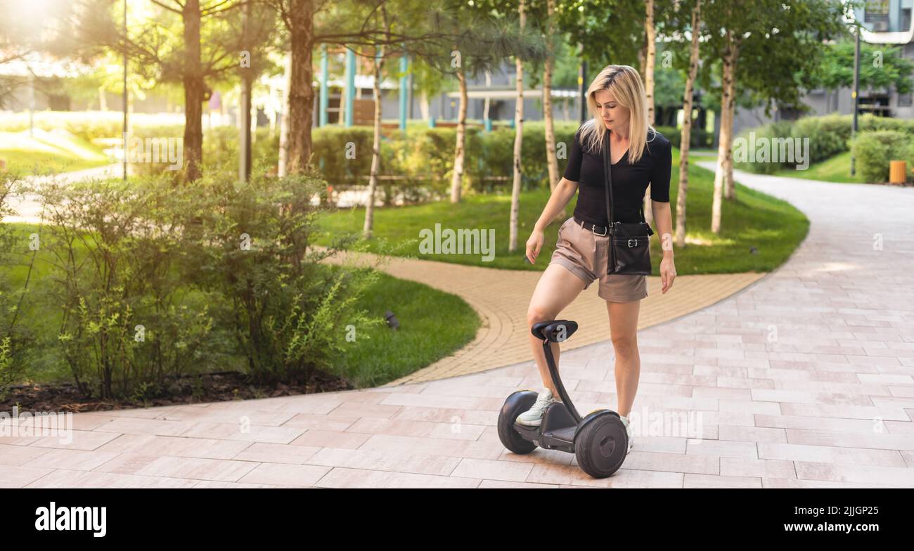 Beautiful woman stand near segway or hoverboard. self balancing ...
