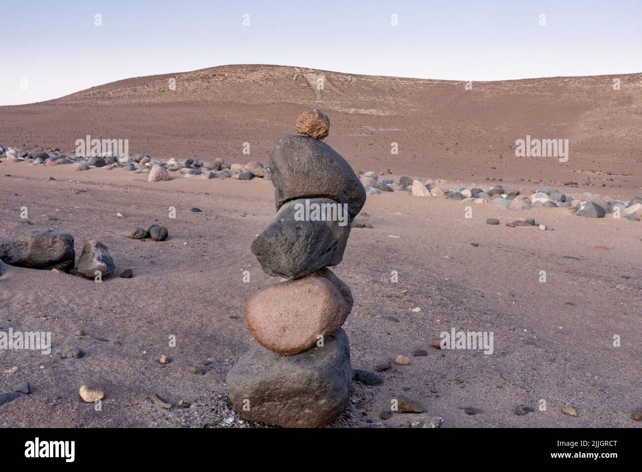 Rock cairns built by visitors at the prehistoric Giant of the Atacama ...