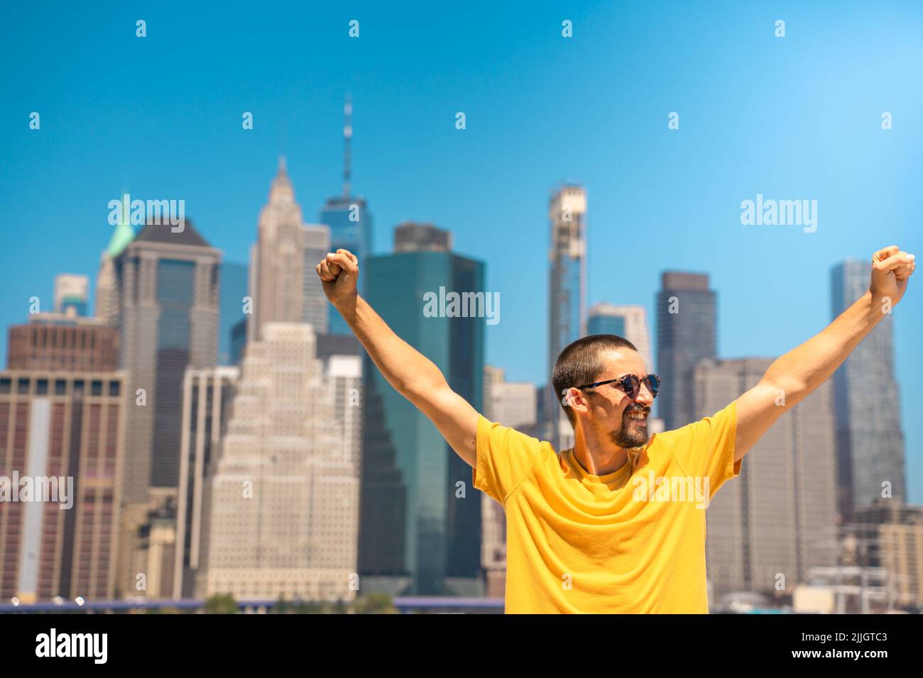 Young attractive man with raised arms happy smiling win celebration in ...