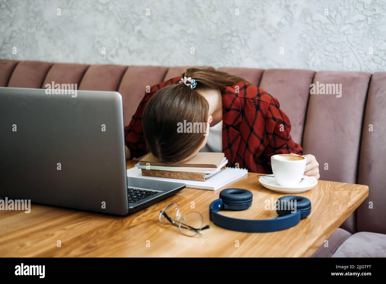Student girl studying hard exam and sleeping on books in cafe. Tired ...