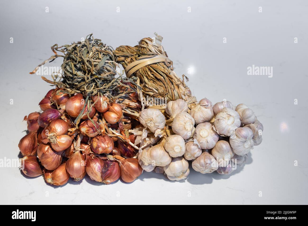 Garlic and Shallot Bundle in studio light on the white marble surface ...