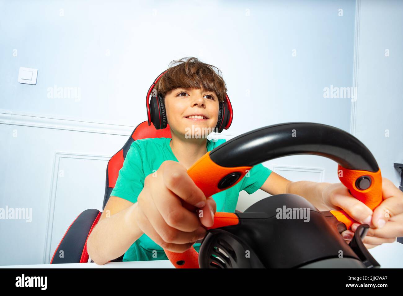 Cute boy in headphones with steering wheel play race game Stock Photo ...