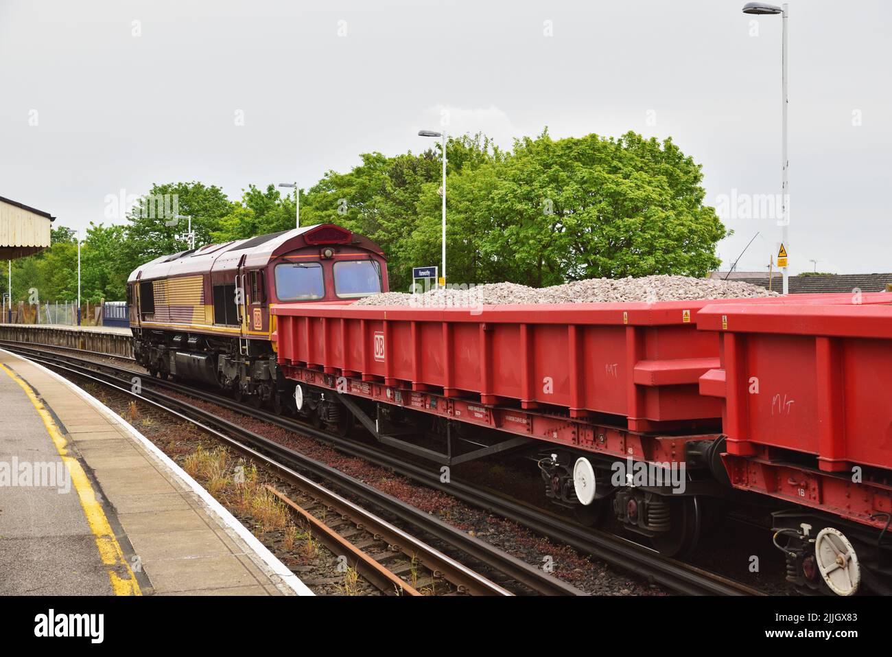 Class 66 no. 66031 brings up the rear of a ballast train passing ...