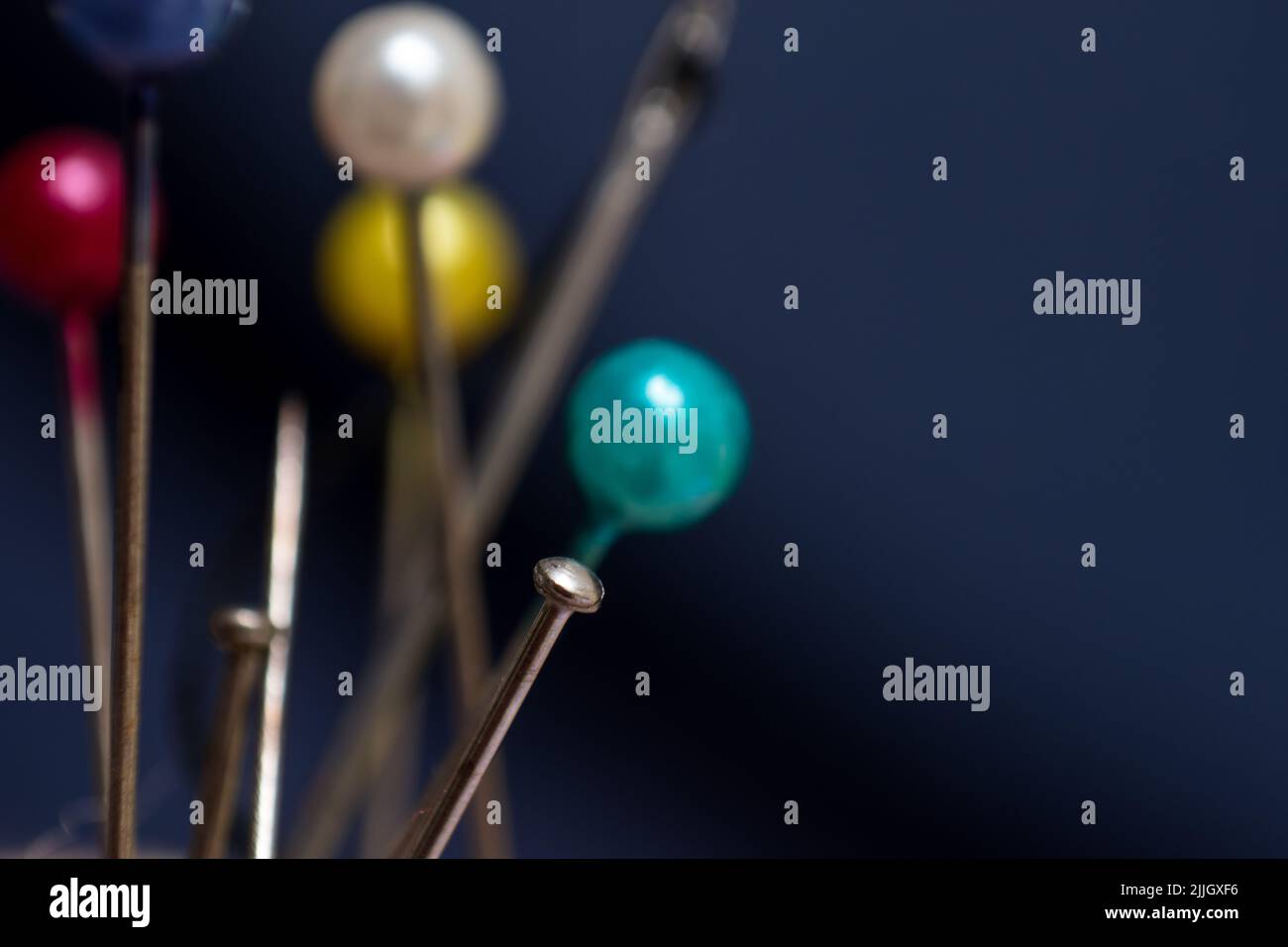 A Close up of some needles and tailor stuff on blue wall Stock Photo ...