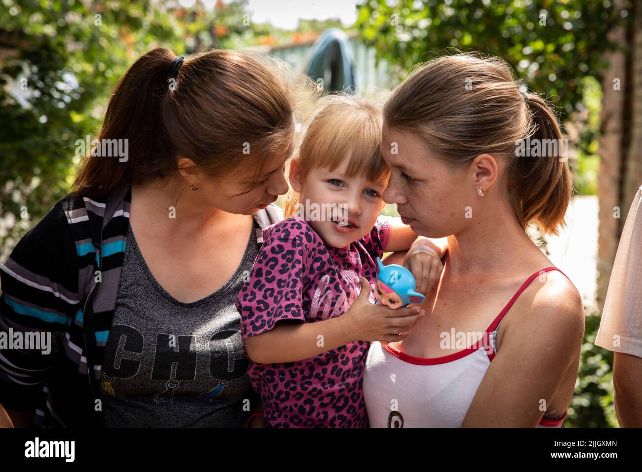 Sveta (L) and Angela (R) hug Lila (C) in her new home in Slovyansk ...