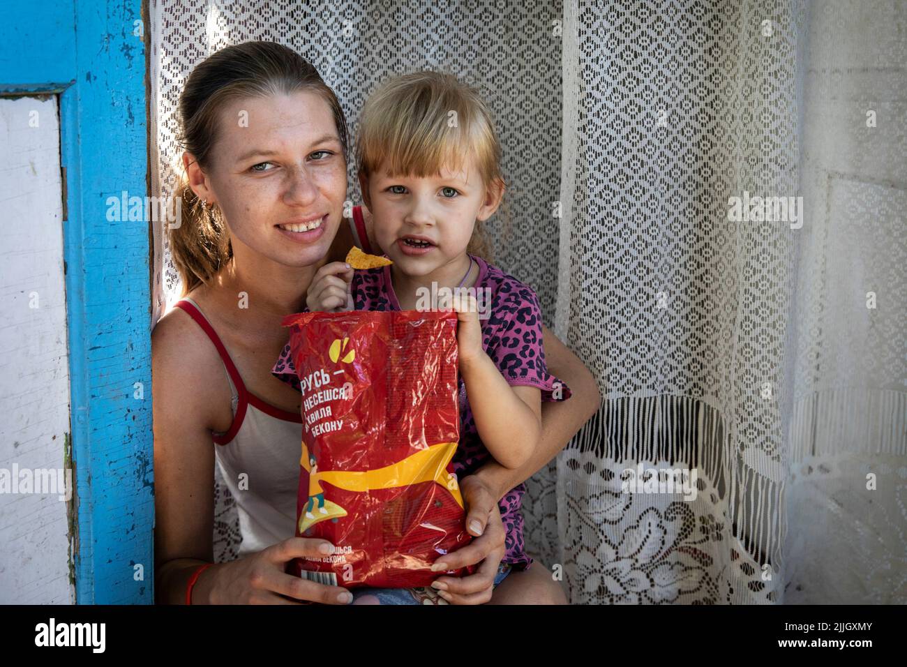 Angela hugs Lila while she eats potato chips in her new home in ...