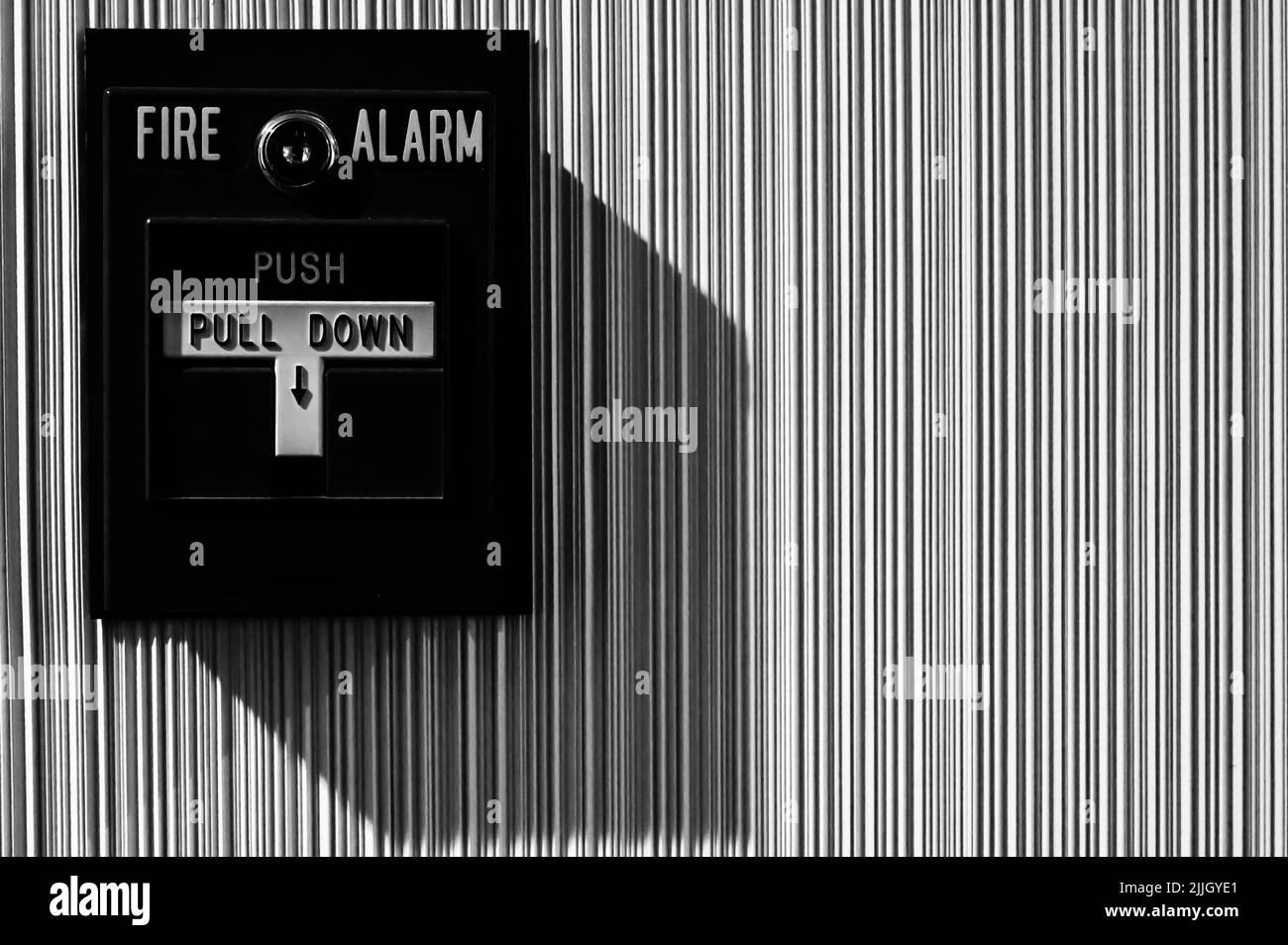 Selective focus on a wall mounted fire alarm switch in a empty hallway ...