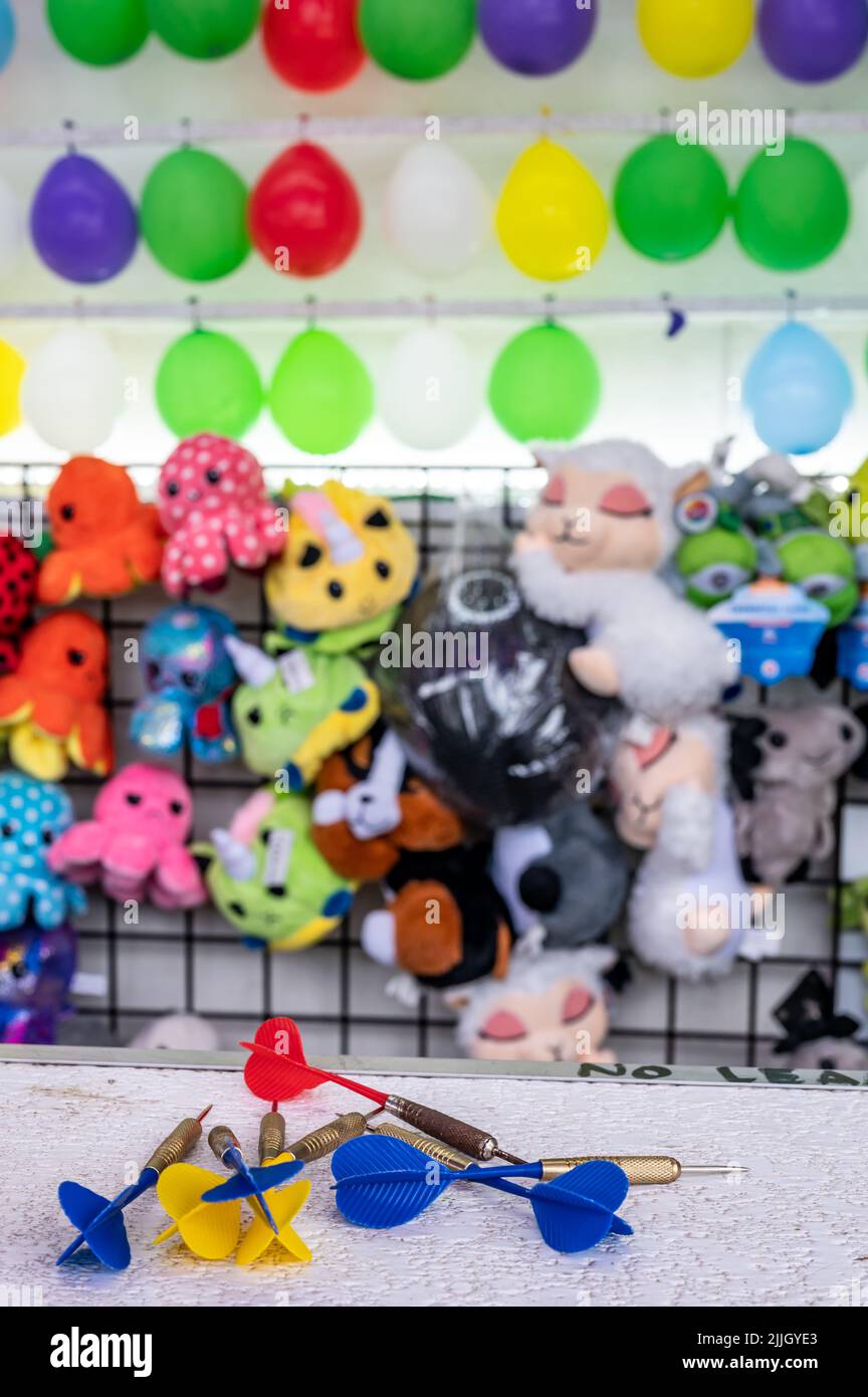 selective focus on darts sitting on a ledge with a wall of balloon ...