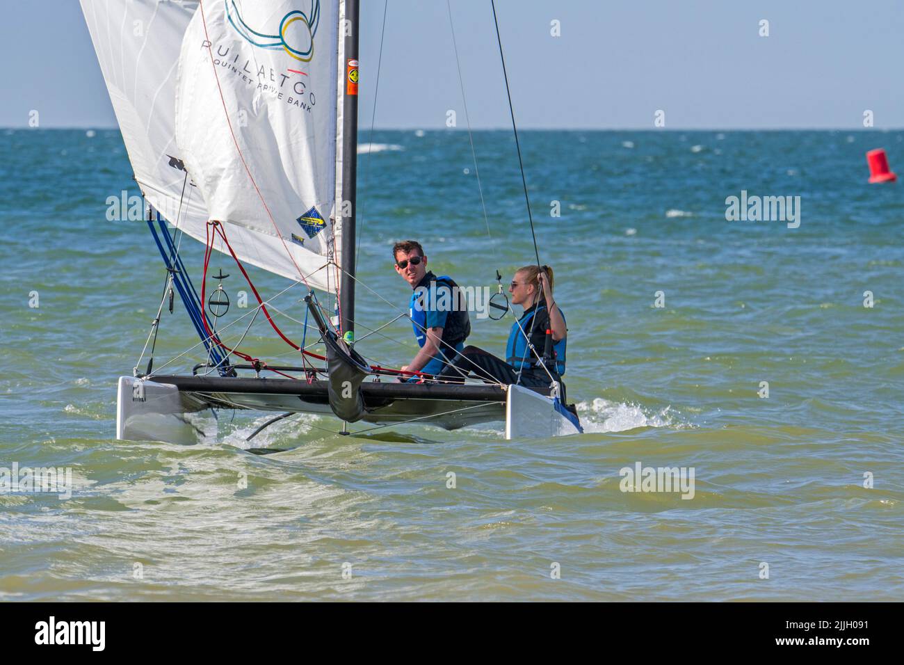 Duo sailing with beachable catamaran at sea Stock Photo - Alamy