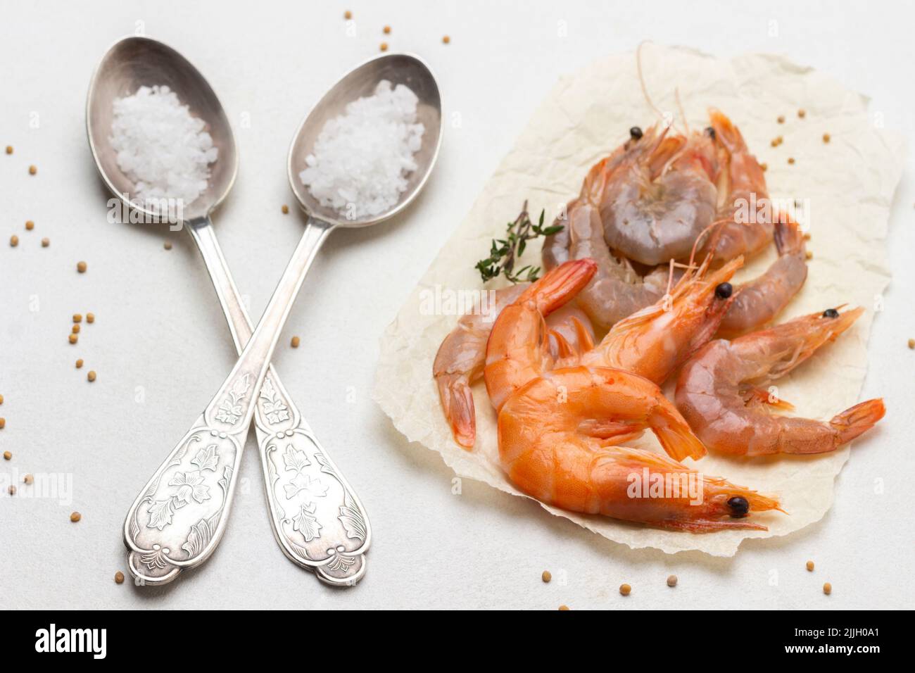 Shrimps on paper. Two spoons of salt. Top view. White background Stock ...