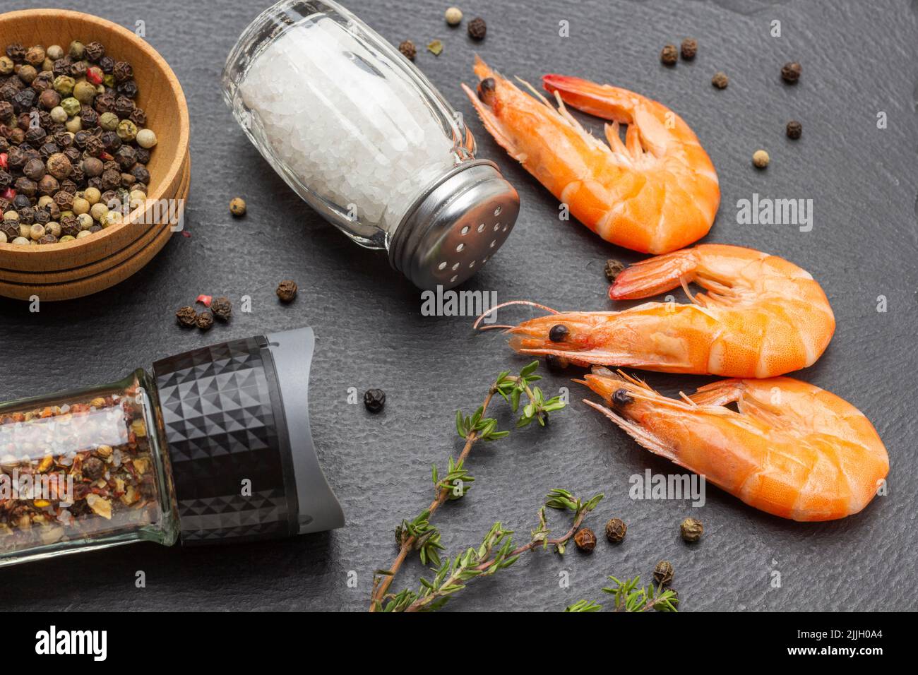 Shrimps, spices and salt in glass salt shaker. Top view. Black ...