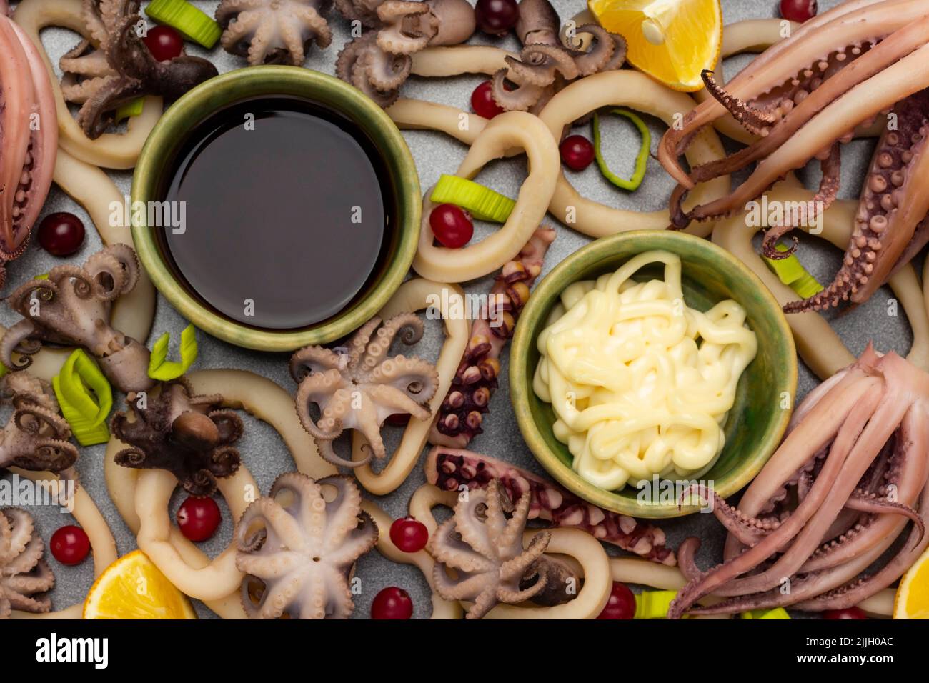 Sauces in bowls and seafood, octopus tentacles and octopus babies. Flat ...