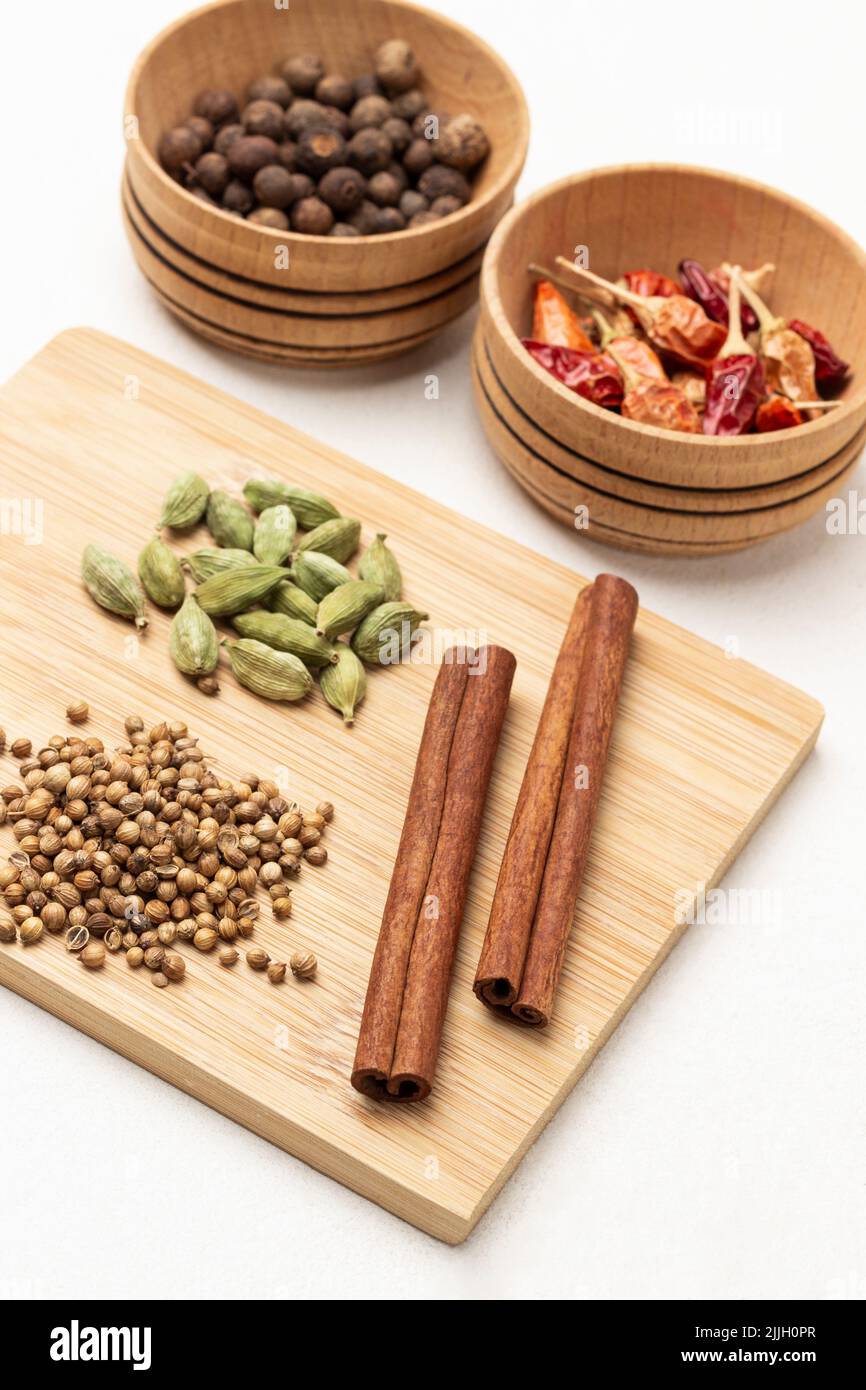 Cinnamon sticks, coriander seeds and cardamom on wooden board. Allspice ...