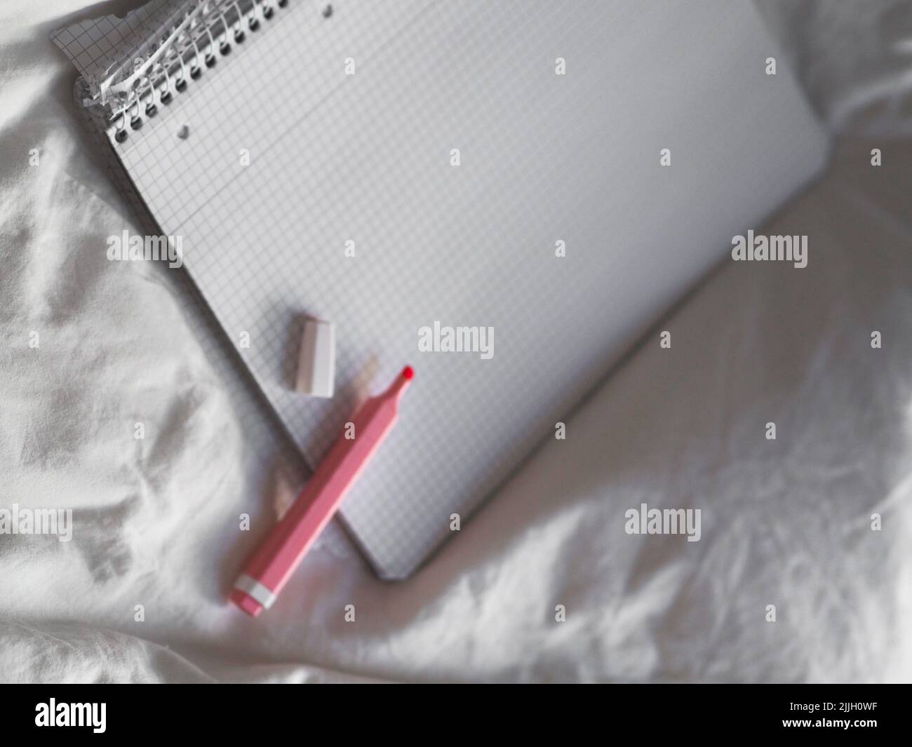 The top view of the pink highlighter pen on the squared paper of the ...