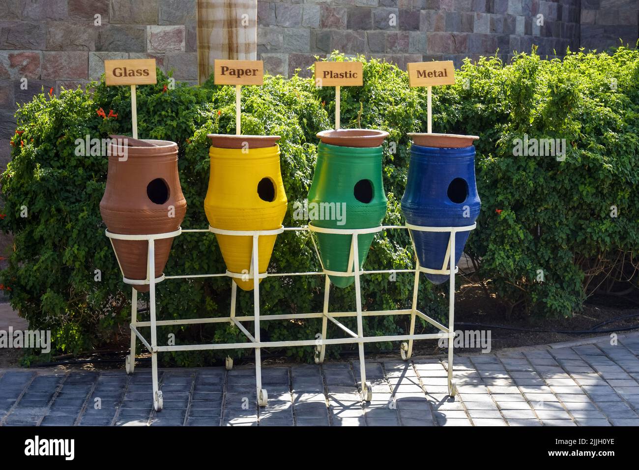 Multi-colored clay bins for separate waste collection. Urns with signs ...