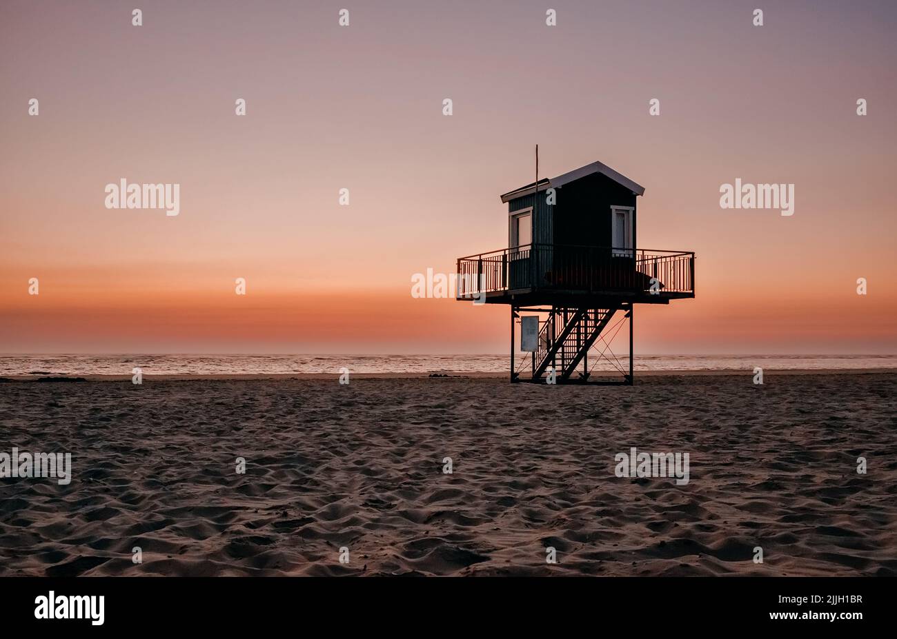 colorful sunset on the beach, mud flat, lifeguard tower on the beach ...