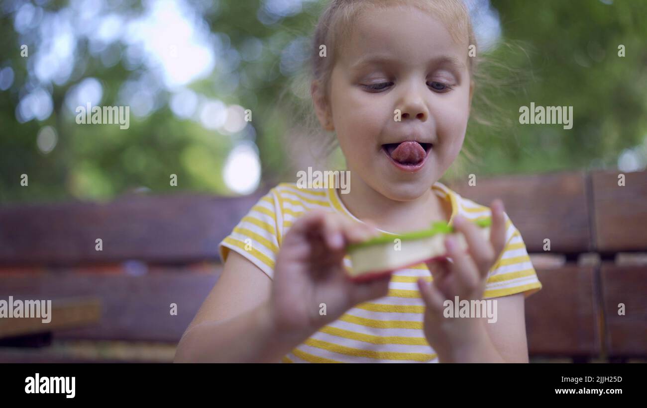 Closeup of cute little girl eats ice cream. Close-up of child girl ...